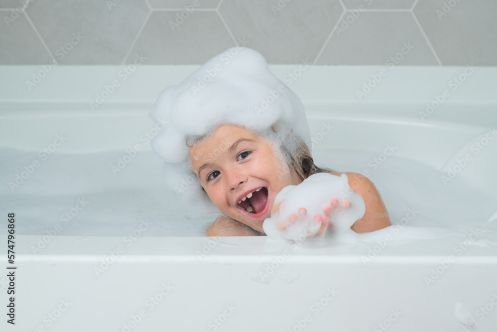 Kids shampoo. Kid bathing in a bath with foam. Funny kid face bathed in ...