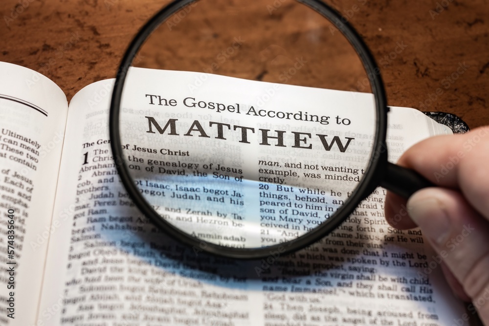 title page book of Matthew close up using magnifying glass in the bible ...