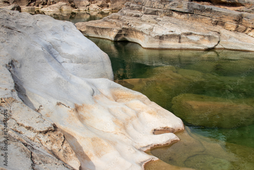 Smooth limestone leads down toward the inviting pool of water with ...