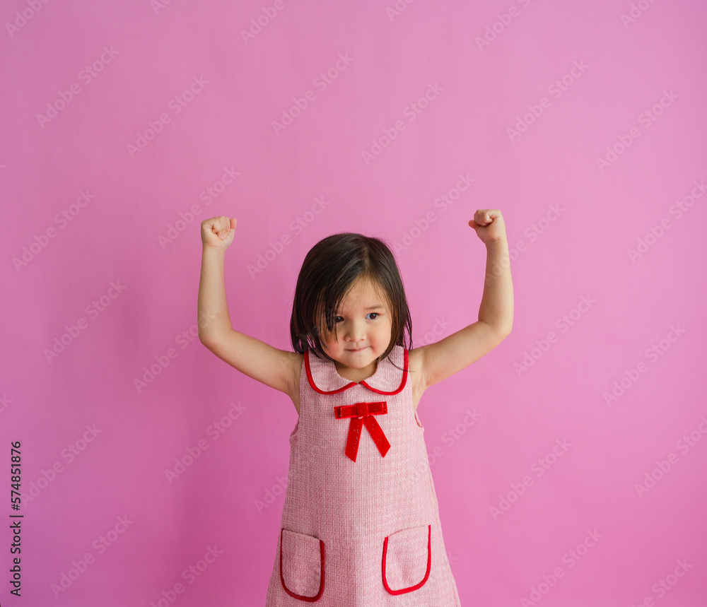 Cute elementary girl flexing muscles in front go pink backdrop Stock ...