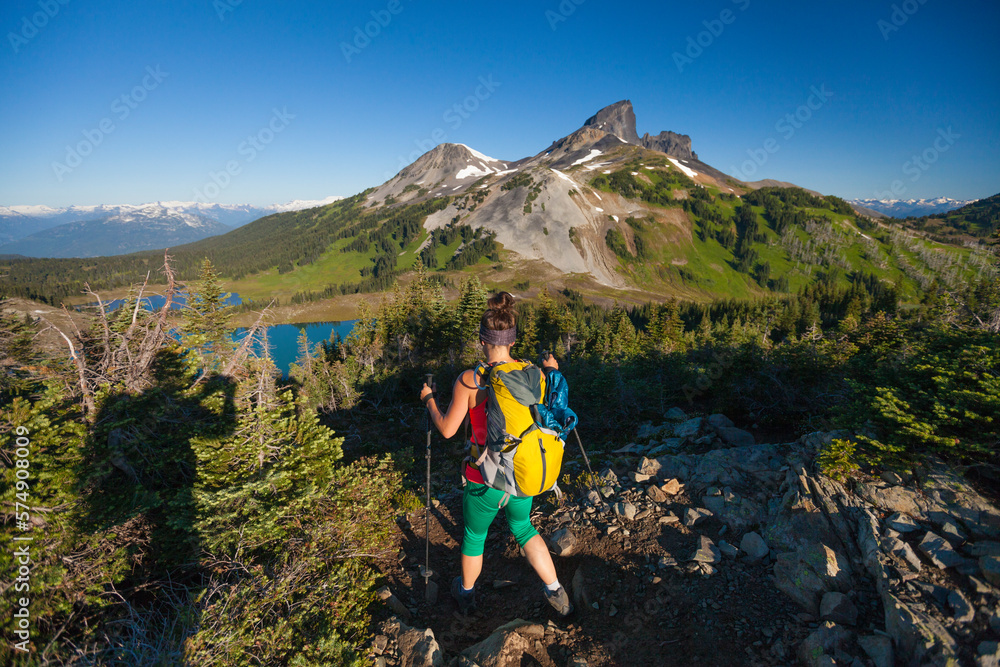 Fotka „Aphotographer takes a picture of a young woman hiking on the ...