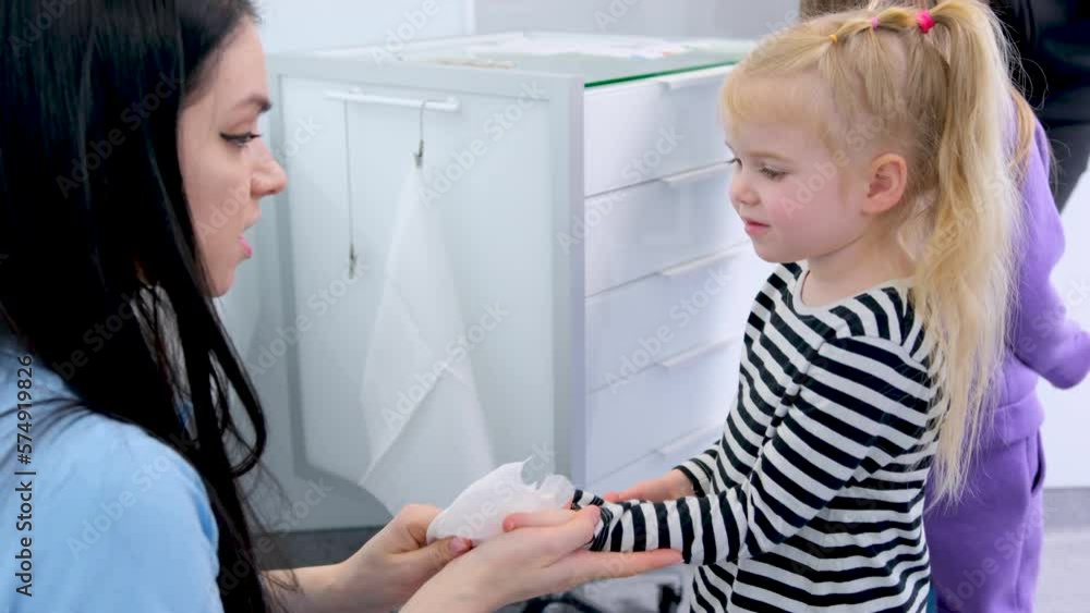 nurse doctor or teacher wipes hands with wet napkin to child talking ...