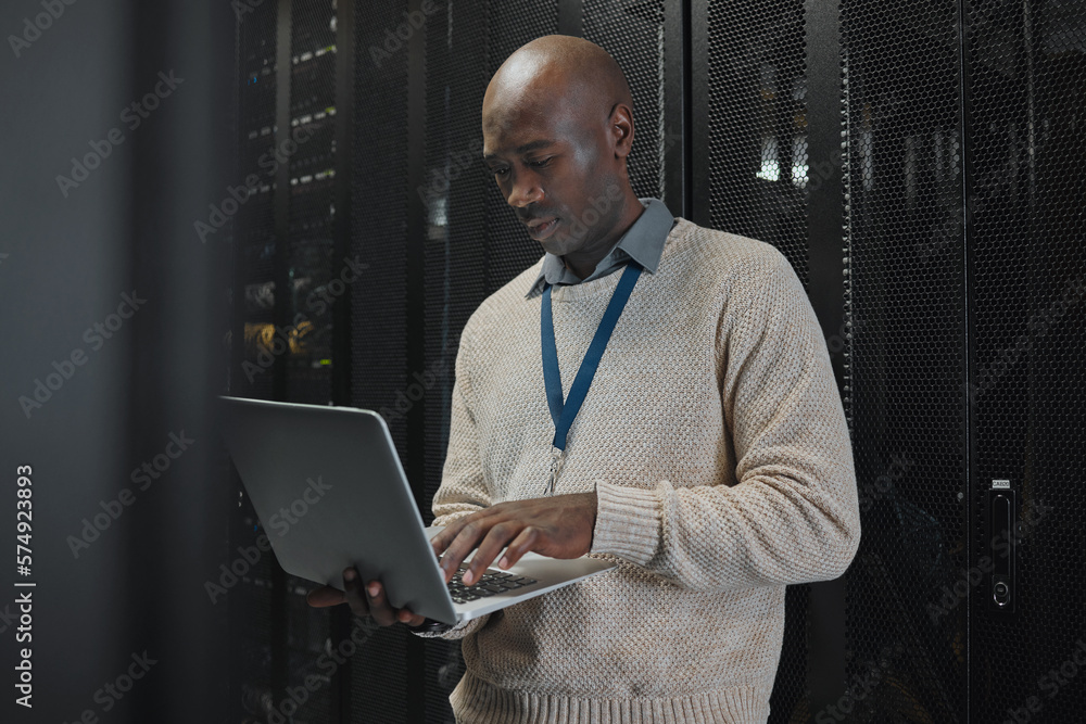 Laptop, server room and black man or technician in data center ...