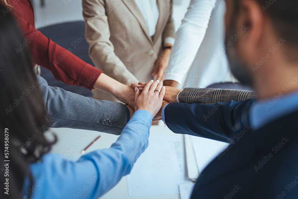 Close up top view of young business people putting their hands together ...