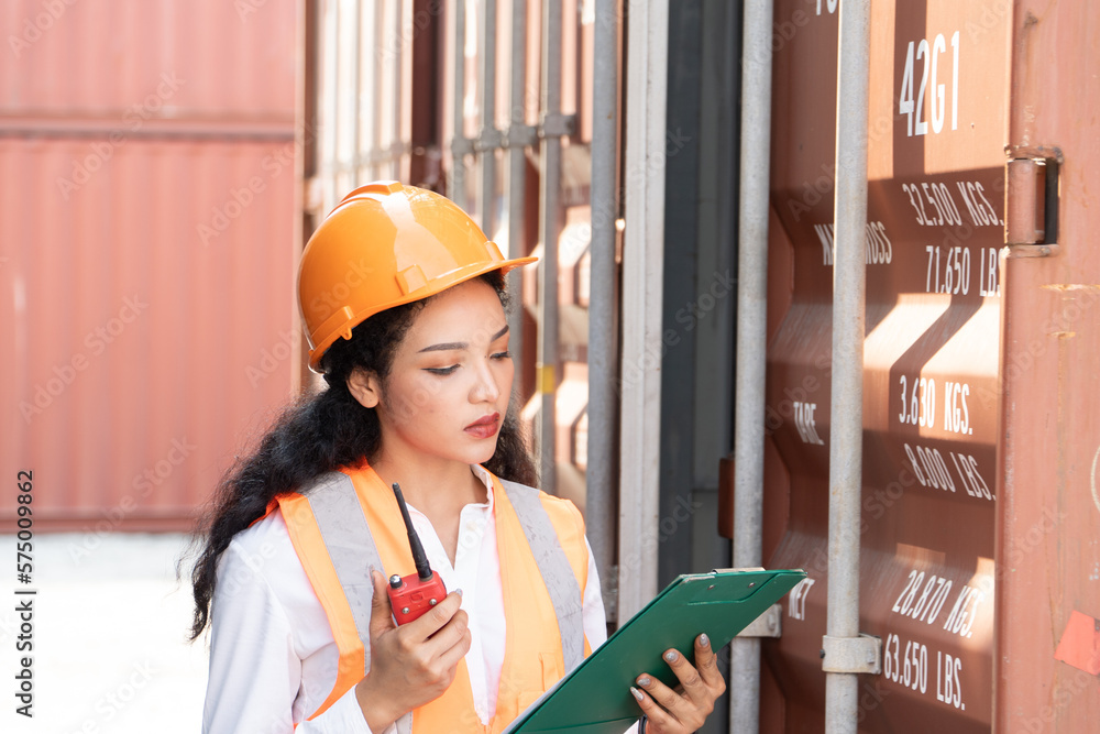 Professional asian female workerusing walkie-talkie in shipping yard ...