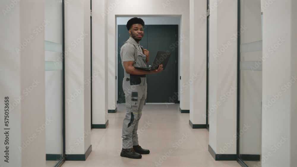 African-American security cameras installer in uniform stands in ...