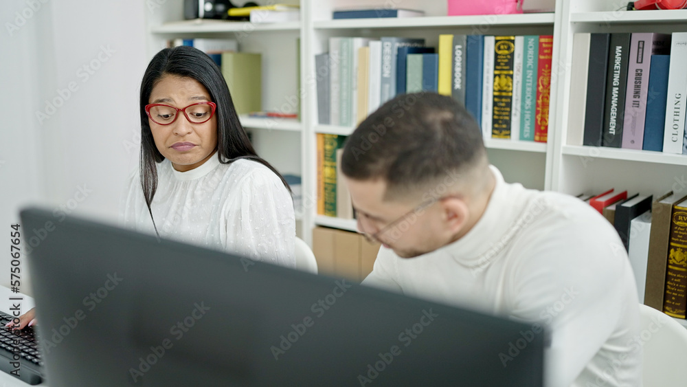 Man and woman students using computer studying at university classroom ...