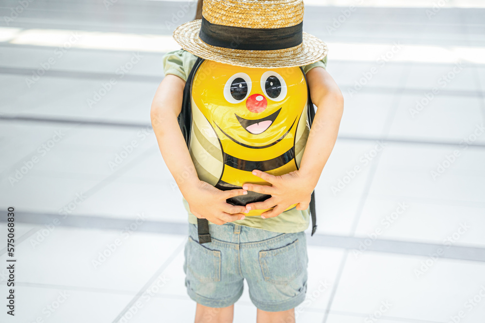 Girl with big funny backpack, bag in airport terminal. Waiting for ...