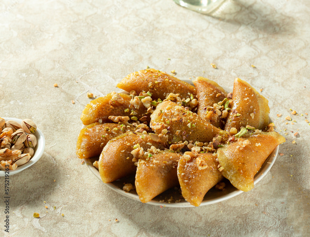 Arabic Oriental sweets , Qatayef dessert stuffed with nuts , made in ...