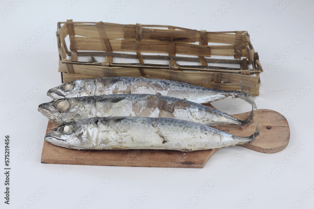 Pindang fish (salted fish) in a bamboo container and on a wooden ...