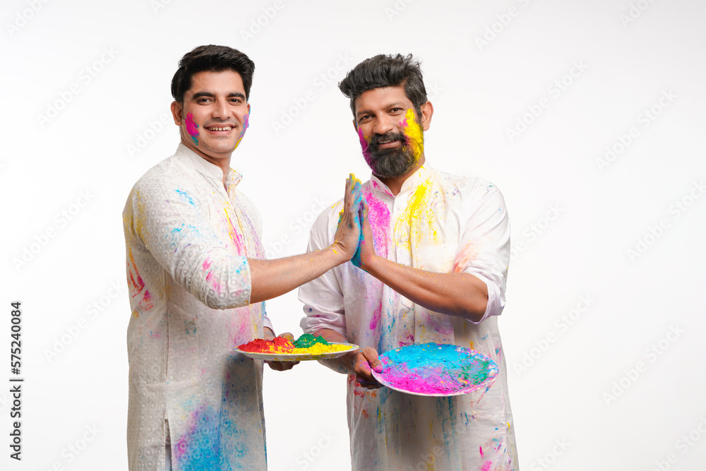 Two indian man applying color to each other and celebrating holi ...