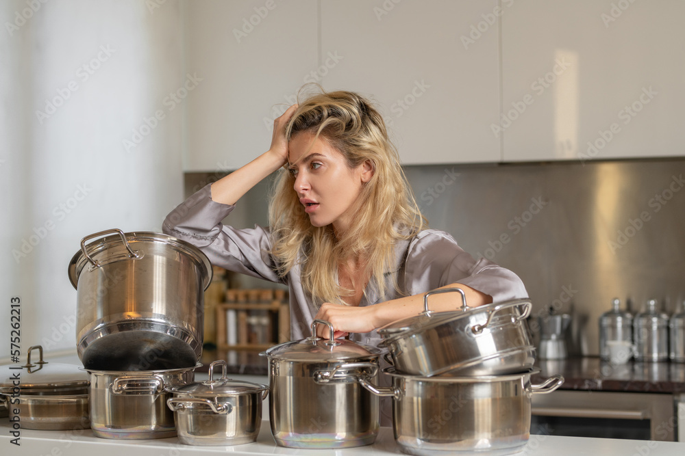Sad woman with cooking pot. Blond beautiful sexy girl cooking in ...