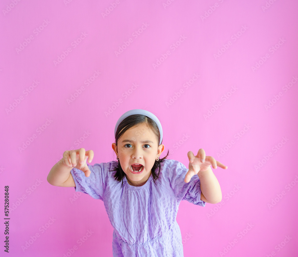 Pretty little girl pretending to be a lion and making a roaring noise ...