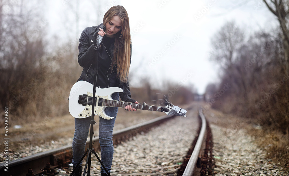 Foto de Beautiful young girl rocker with electric guitar. A rock ...