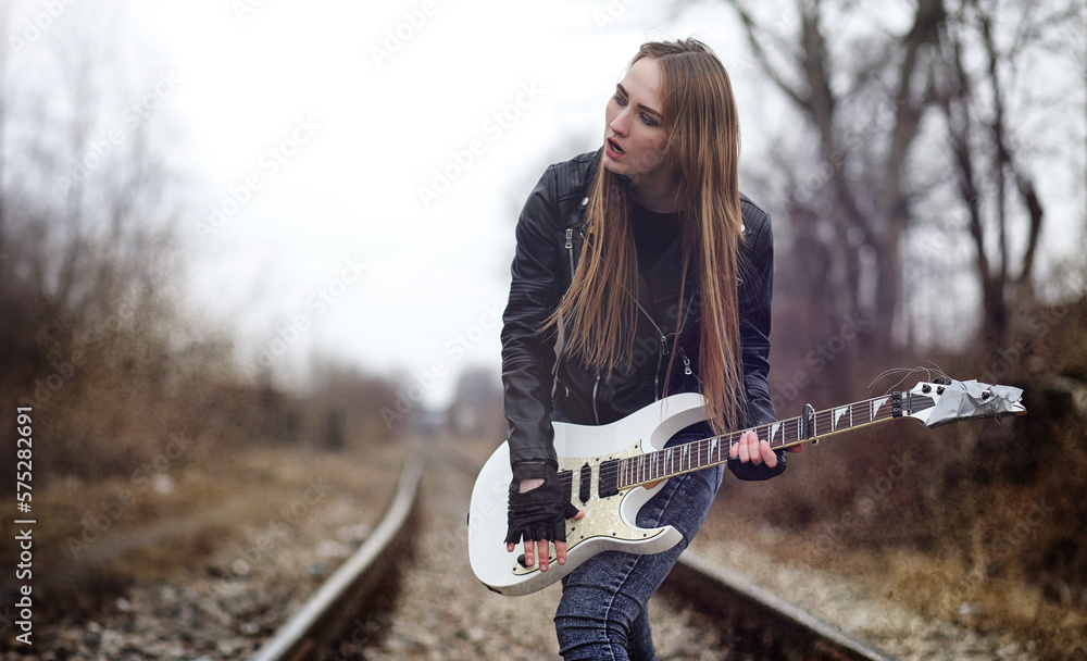 Beautiful young girl rocker with electric guitar. A rock musician girl ...