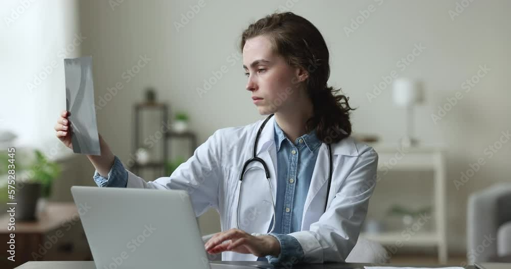 Woman radiologist, medical worker in uniform sits at workplace with ...