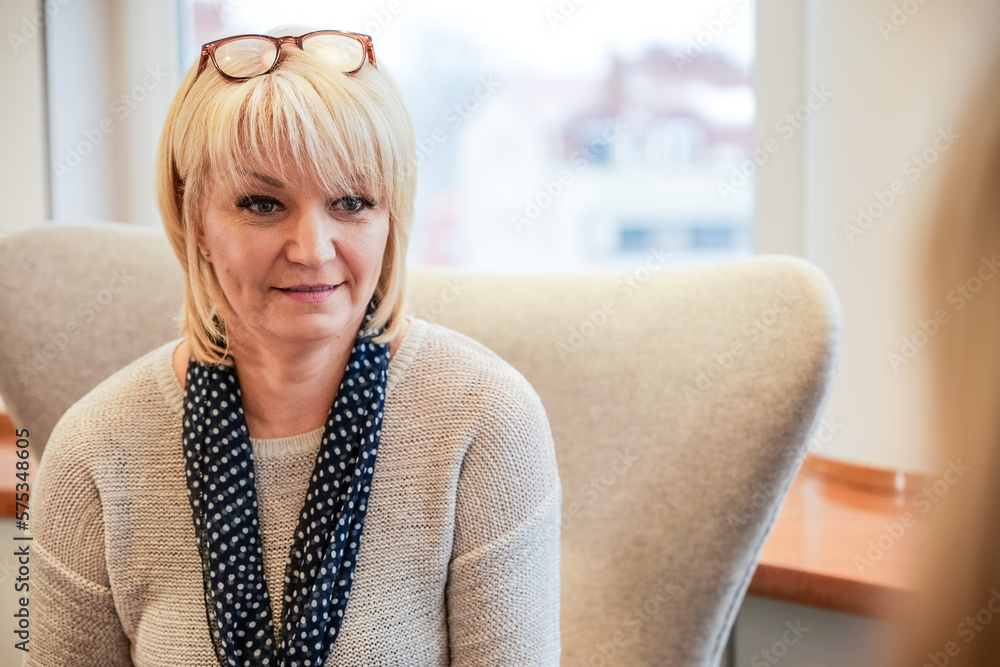 Two women of different generations are talking at a business meeting in ...