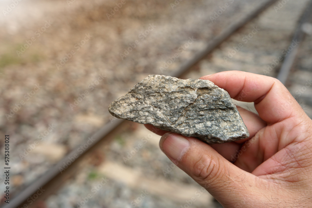 Raw specimen of granite igneous rock stone on Geologist's hand. The ...