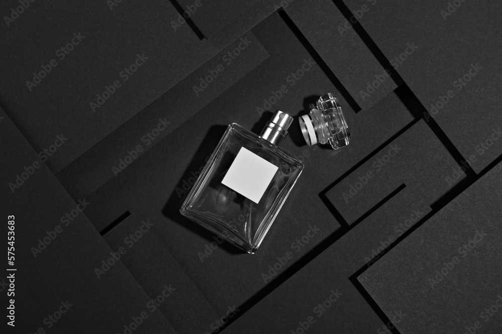 Mockup of glass perfume bottle on a dark multi-layered black background ...