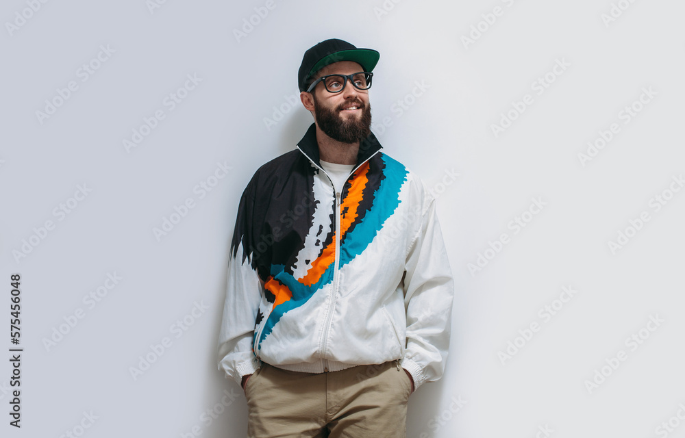 Portrait of a stylish hipster model guy with a beard in glasses, a cap ...