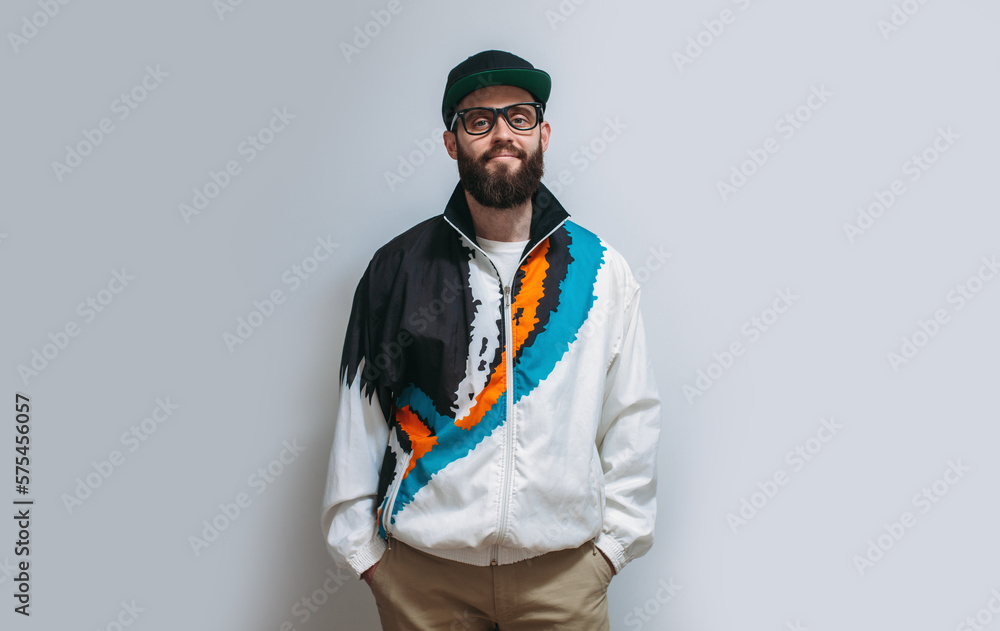 Portrait of a stylish hipster model guy with a beard in glasses, a cap ...