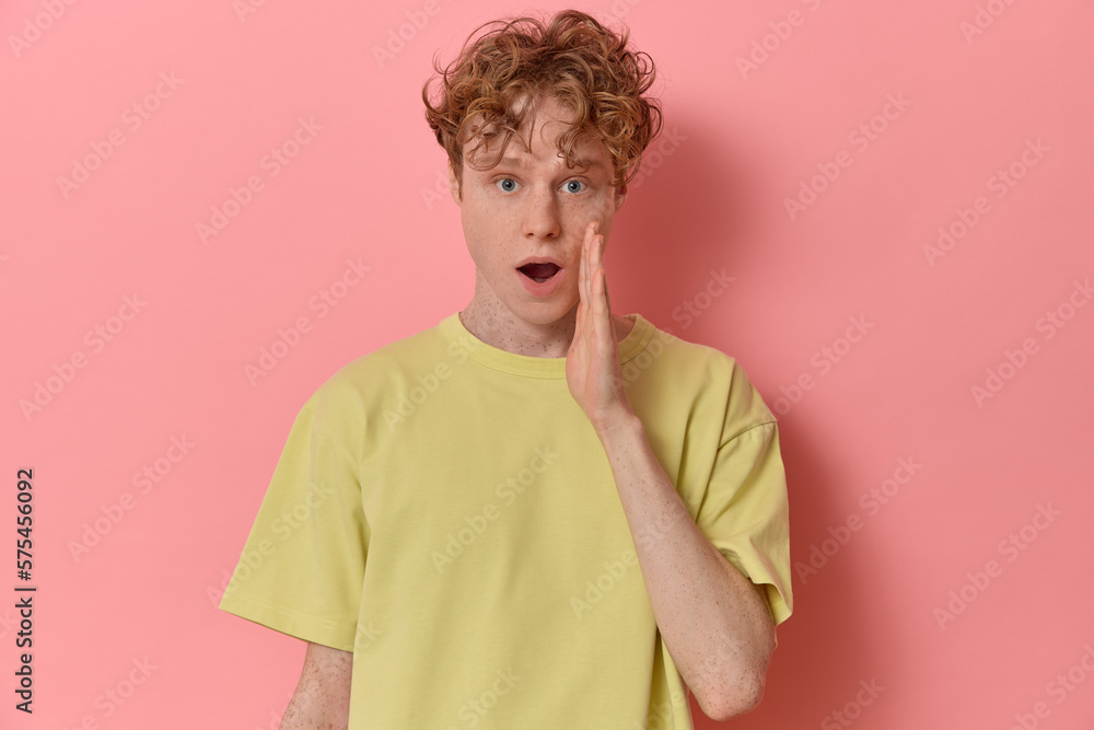 Studio shot of dazed impressed surprised curly-haired man learned ...