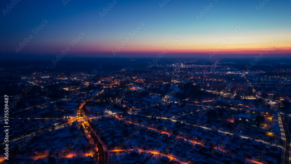 Flight over a city illuminated by a sunset flare. City lantern lights ...