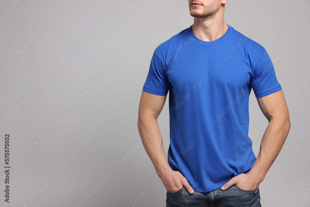 Man wearing blue t-shirt on light grey background, closeup. Mockup for ...