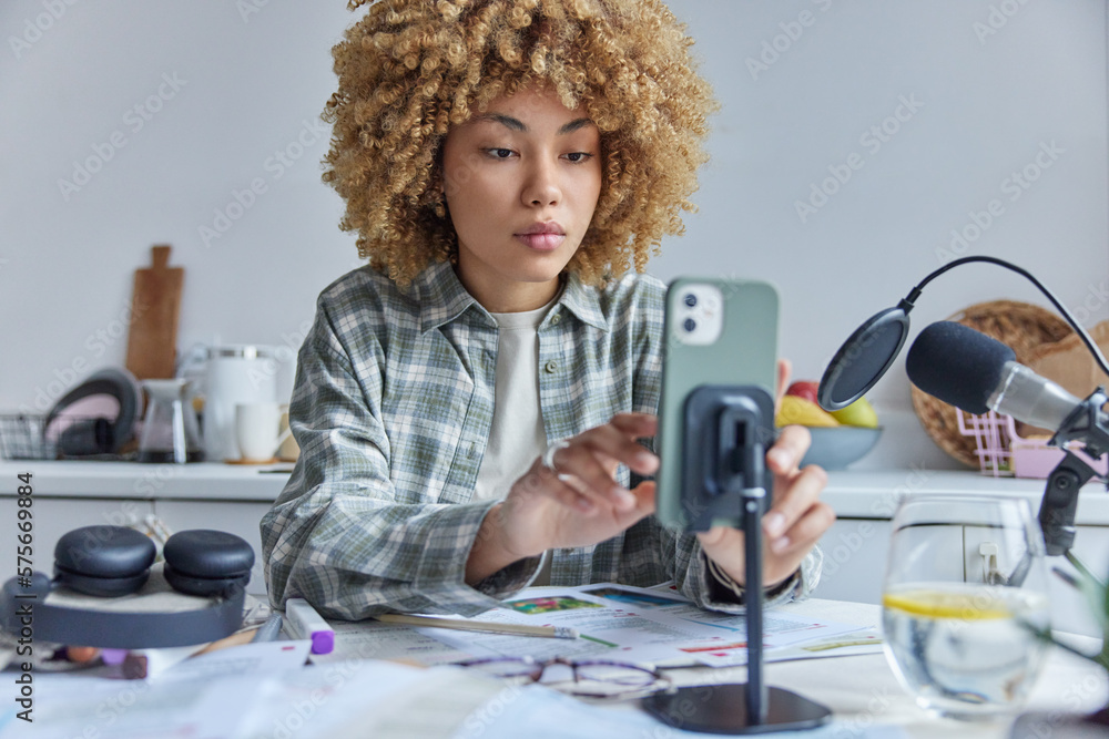 Female tutor with curly hair gives online lesson talks in webcam being ...