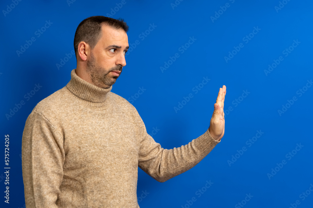 Strict bearded hispanic man showing stop sign, standing with frowning ...