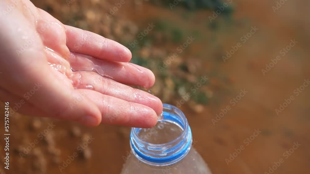 clean water in plastic bottle, dry land on the background. cracked soil ...