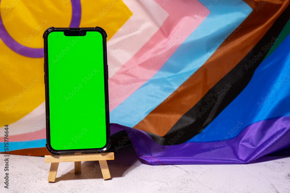 Mobile phone with chroma key on Rainbow LGBTQIA flag made from silk ...