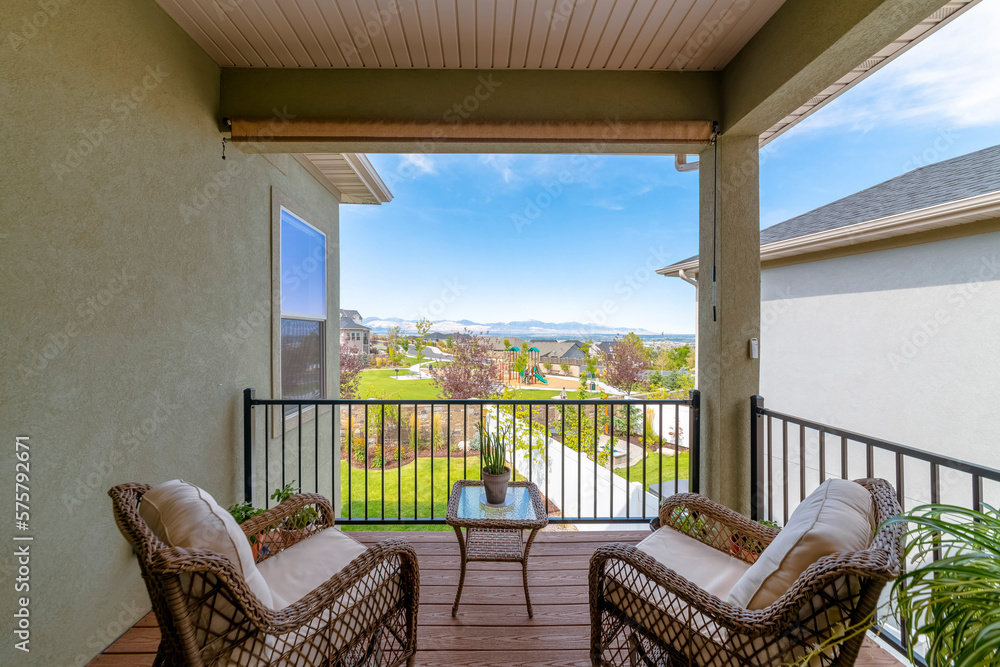 House balcony with woven chairs and table, and small park views with ...