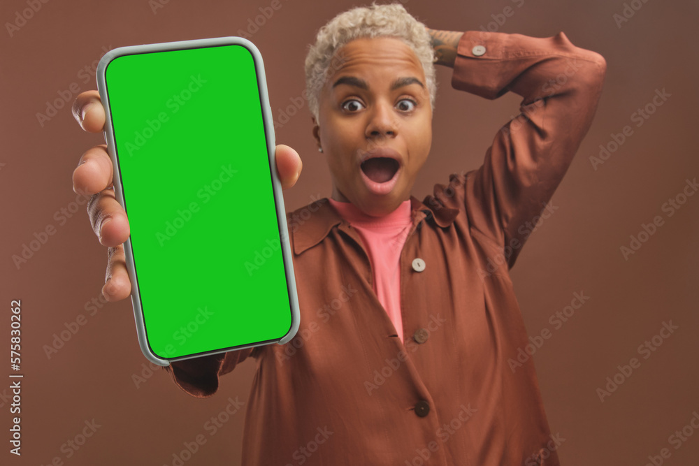 Young shocked African American woman student with mobile phone in hand ...