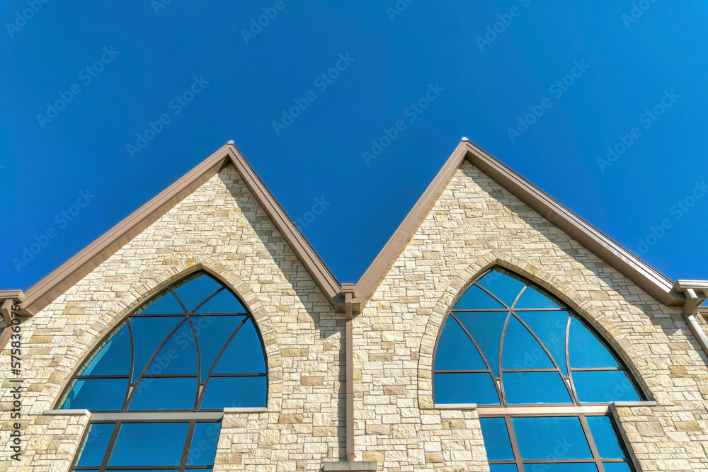 Low angle view of a building with two roof peaks and gothic arch ...