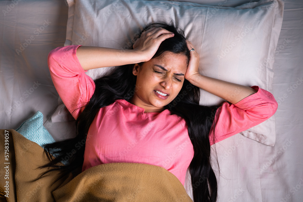 Top view shot of young girl suffering from headache while sleeping on ...