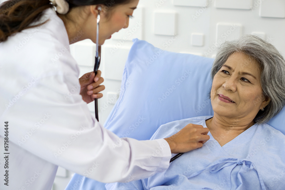 Senior female patient and doctor. Young asian doctor use a stethoscope ...