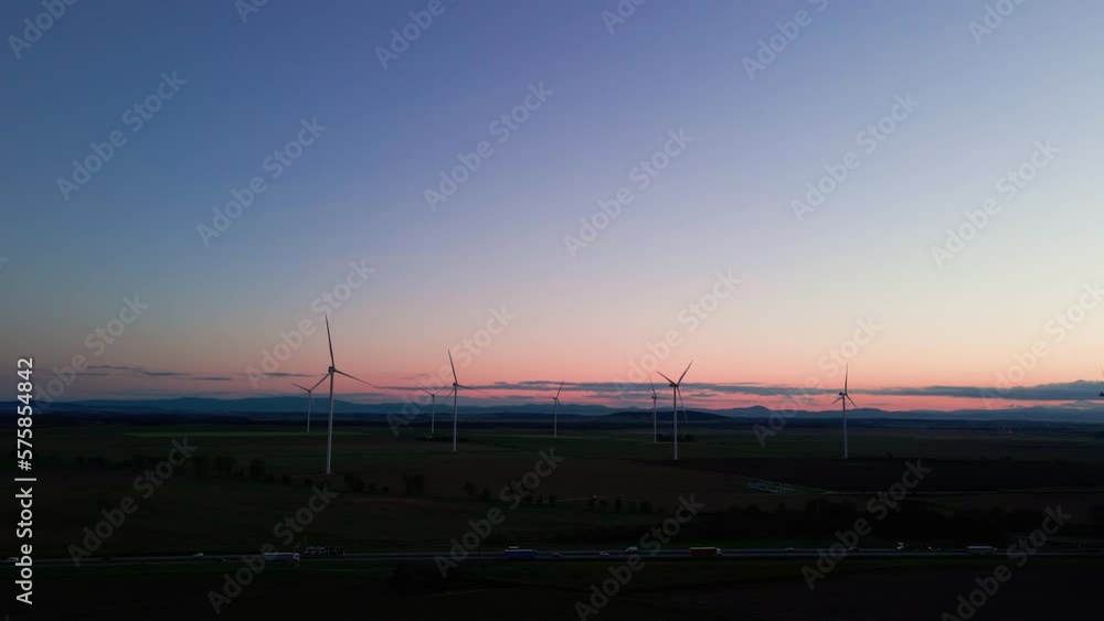 Highway road with car traffic and windmill turbine generator against ...