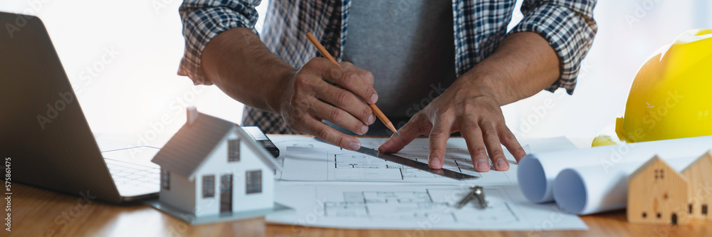 Asian engineer tracing with ruler and blueprint in office to design ...