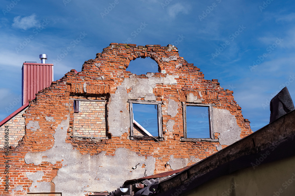 Old abandoned red brick residential building wall with windows holes ...