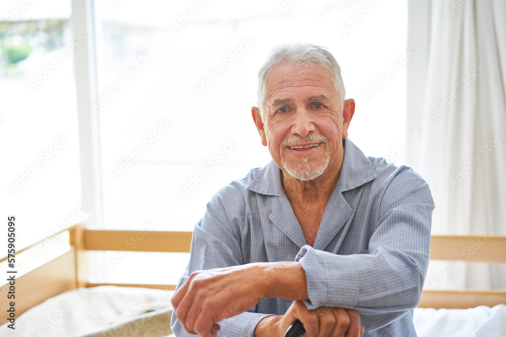 Smiling elderly man sitting on bed at home Stock Photo | Adobe Stock