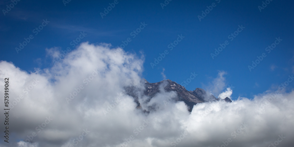 Peak of Mount Kinabalu in background as clouds cover the rest of the ...