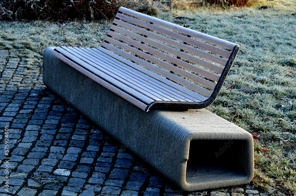 Fotografia do Stock: park bench has a concrete tube base flattened on ...