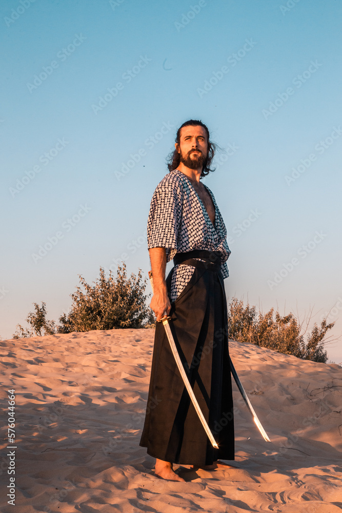 A Japanese warrior in a traditional kimano armed with a katana sword on ...
