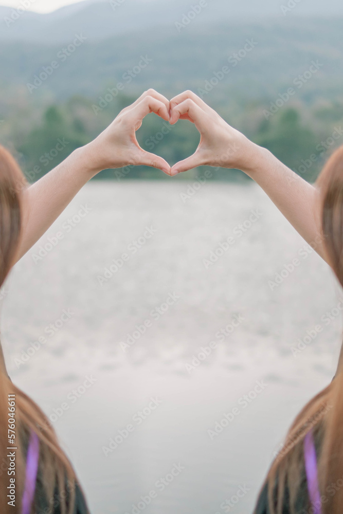male and female couple showing their hands up to form heart symbol to ...