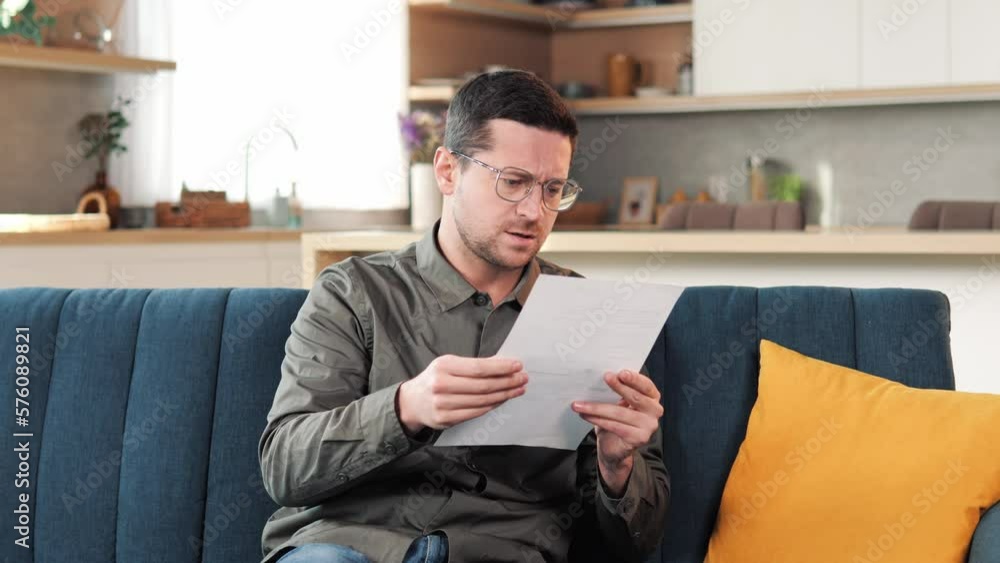 Upset man reading document loan arrears feeling negative emotions ...