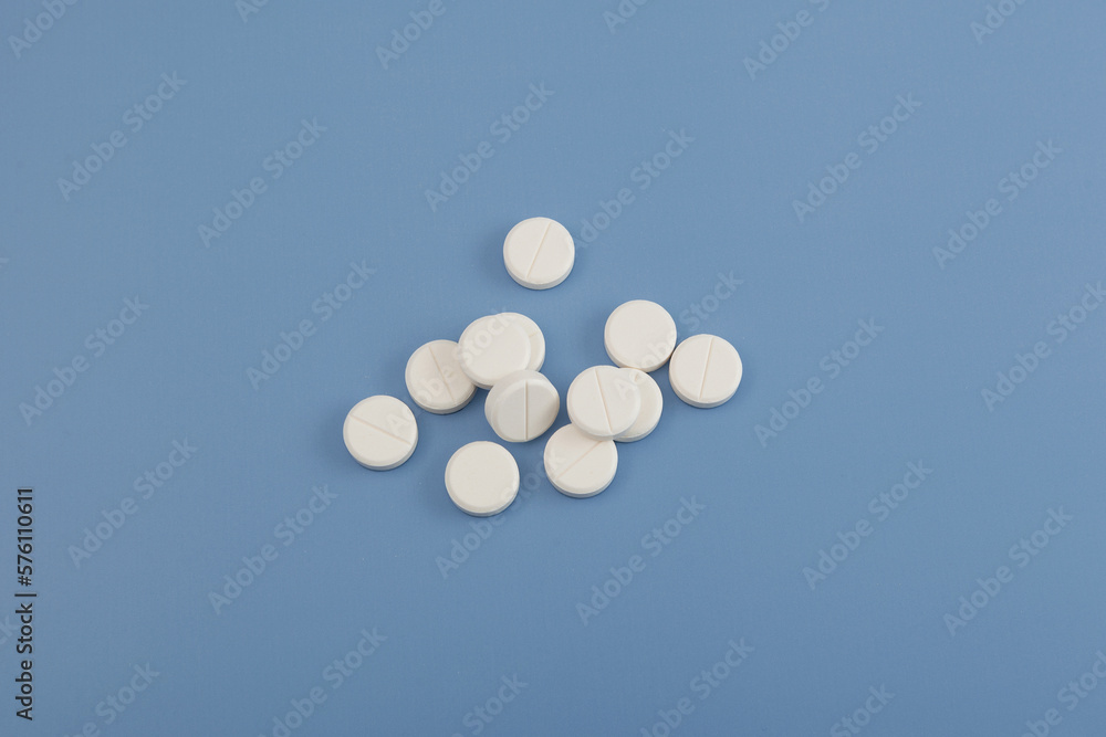 Classic round white tablets on blue background. Traditional medicine ...