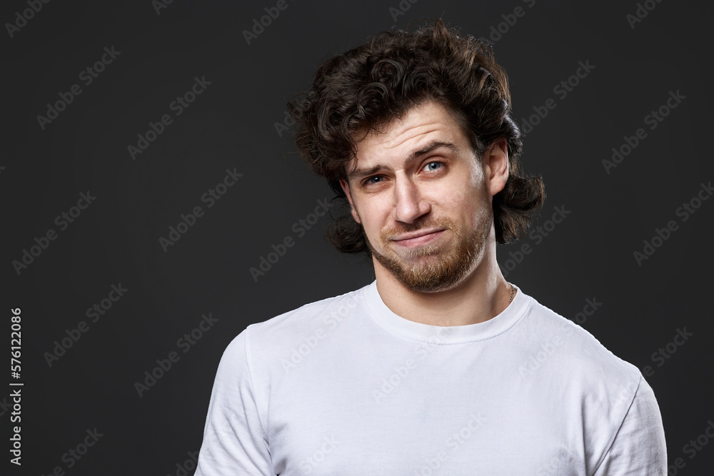 skeptic and nervous man in white t-shirt on dark gray background Stock ...