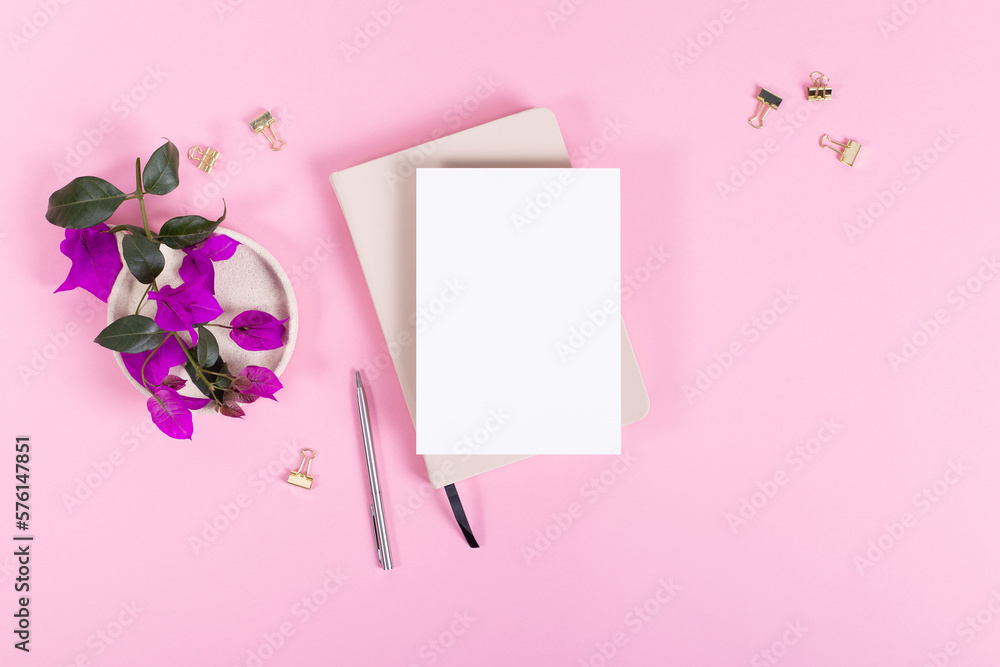 Foto de Hoja blanca encima de libreta color neutro y fondo rosa, con ...