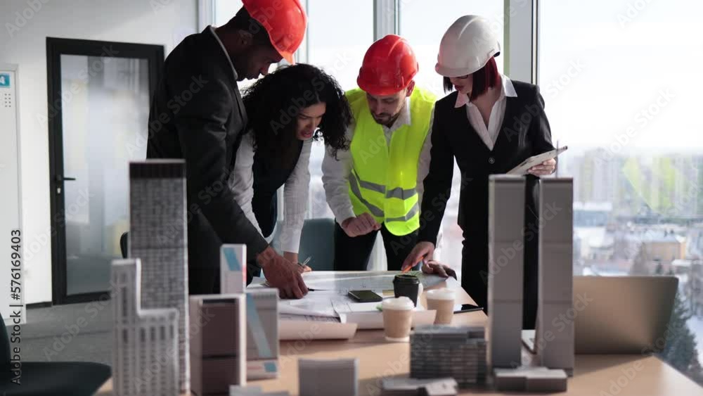 Group of four multiracial people architects standing near desk with ...